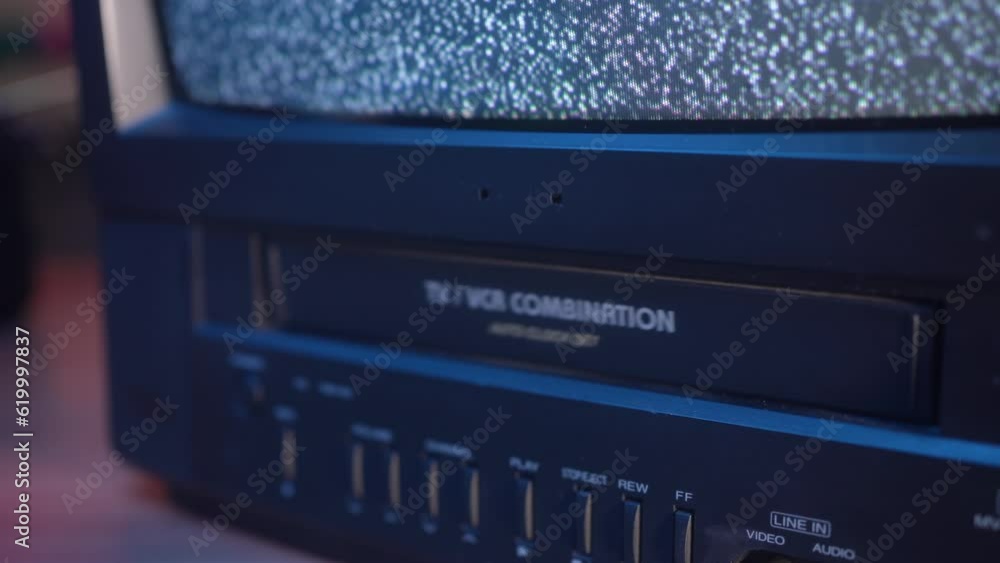 Pushing a VHS Video Cassette Tape Inside the VCR of an Old TV Stock ...