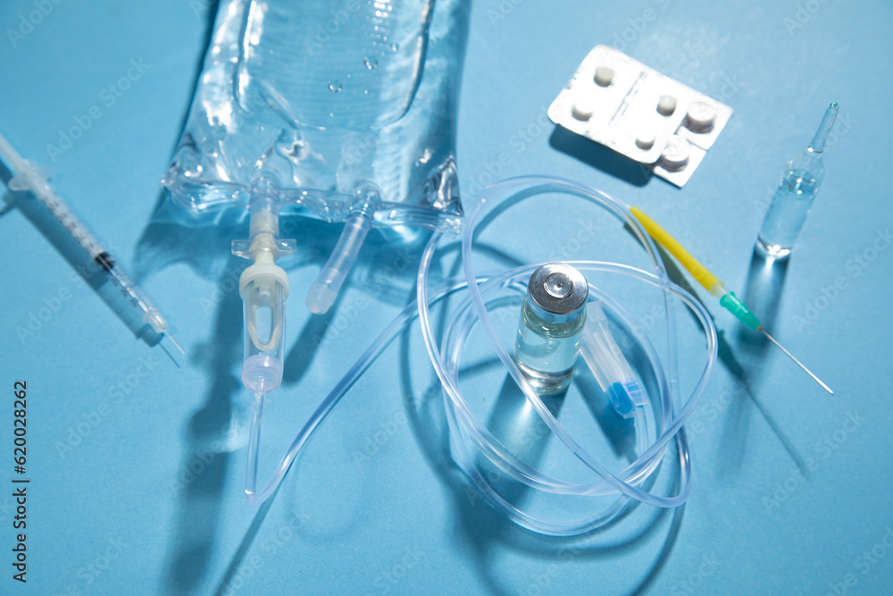 Infusion bag, syringe, medical ampoules in the blue background. IV drip ...