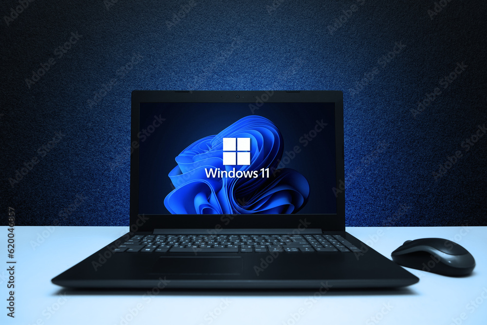 Windows 11 logo on the screen laptop computer with mouse on black ...