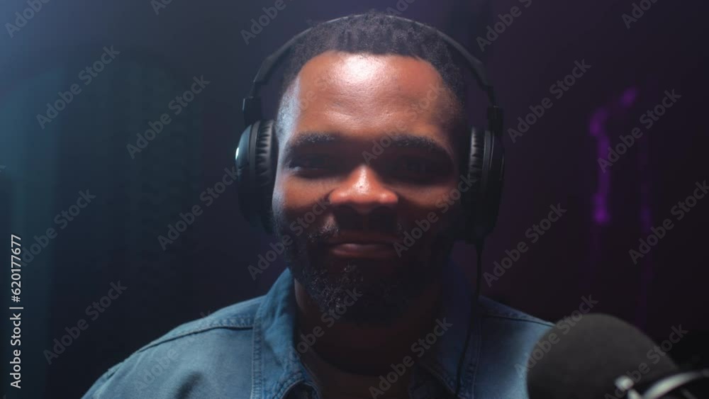 Portrait: An African-American guy speaks into a microphone, creates a ...