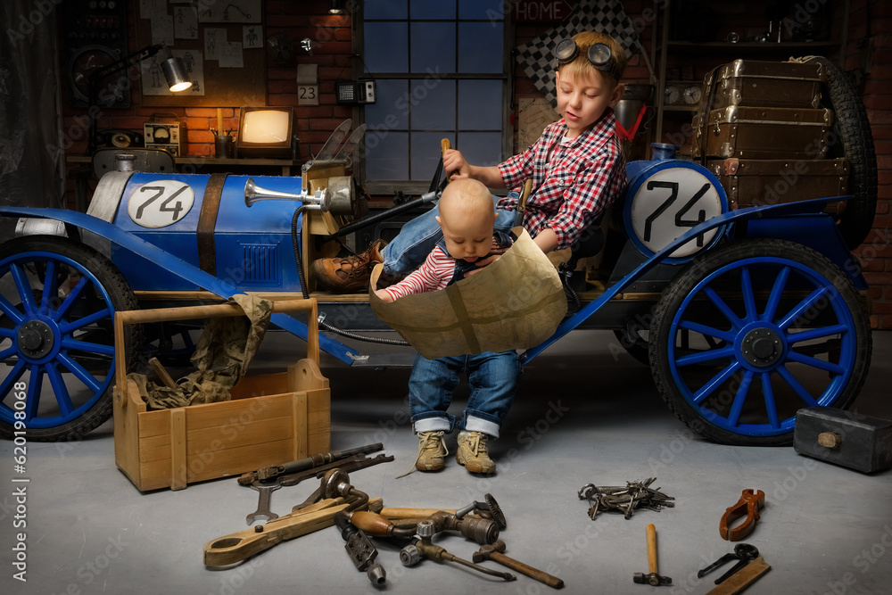 Little boys play in the garage and pretend they are mechanics. Children ...