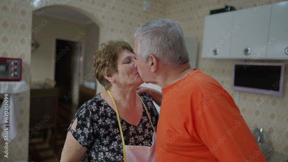 Older Couple Kissing In Kitchen Wife Kisses Husband Goodbye To Start The Day Senior Couple