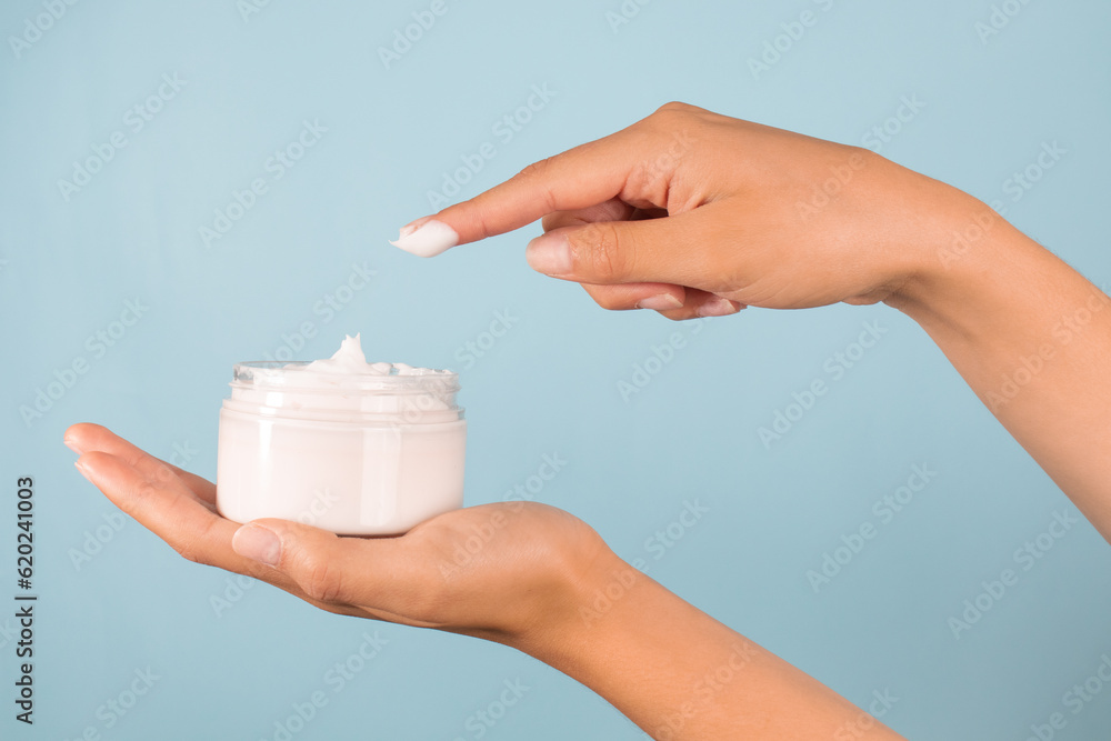 Crop woman taking cream with finger from jar Stock Photo | Adobe Stock