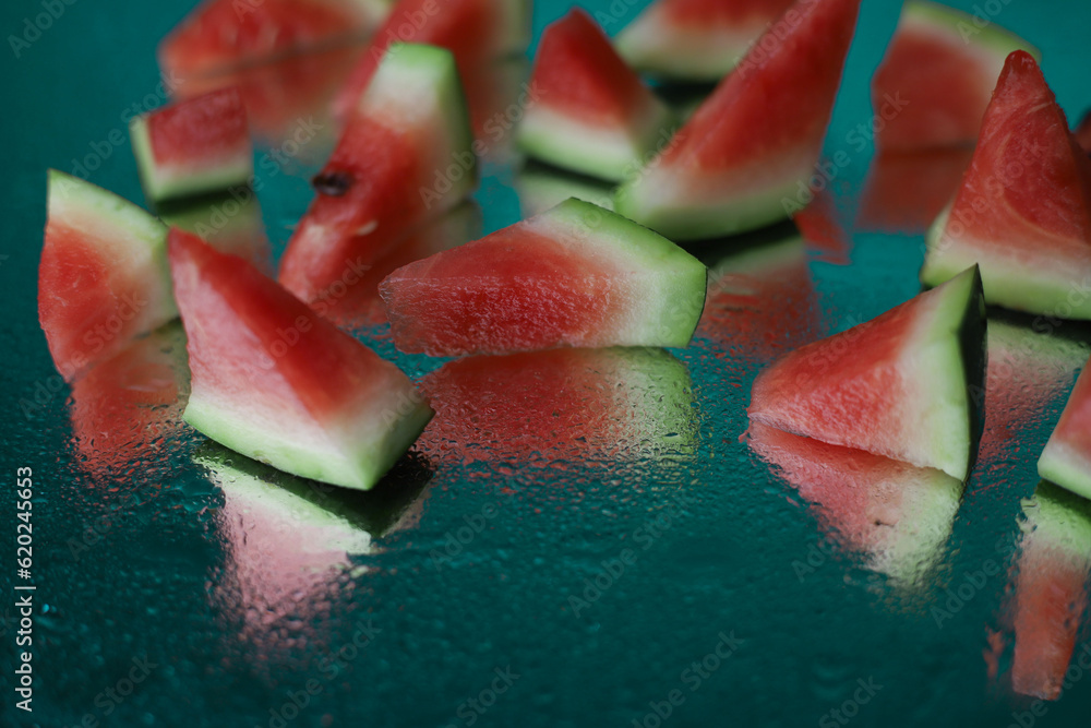 ripe juicy summer watermelon slices with water drops on a wet mirror ...
