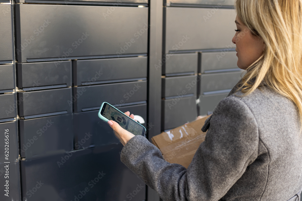 Beautiful woman picking up a package from a smart electronic steel ...