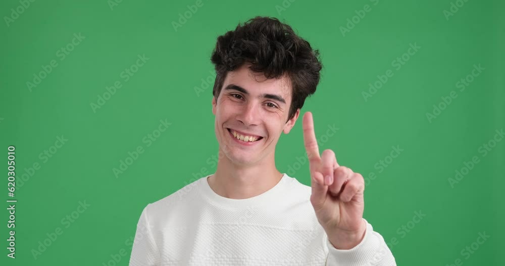 Sly Caucasian man over green background wagging his finger in a teasing ...