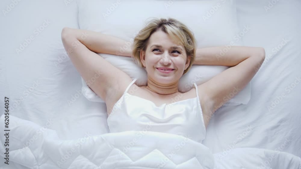 Excited full of energy and positivity woman in her 40s lying in fresh ...