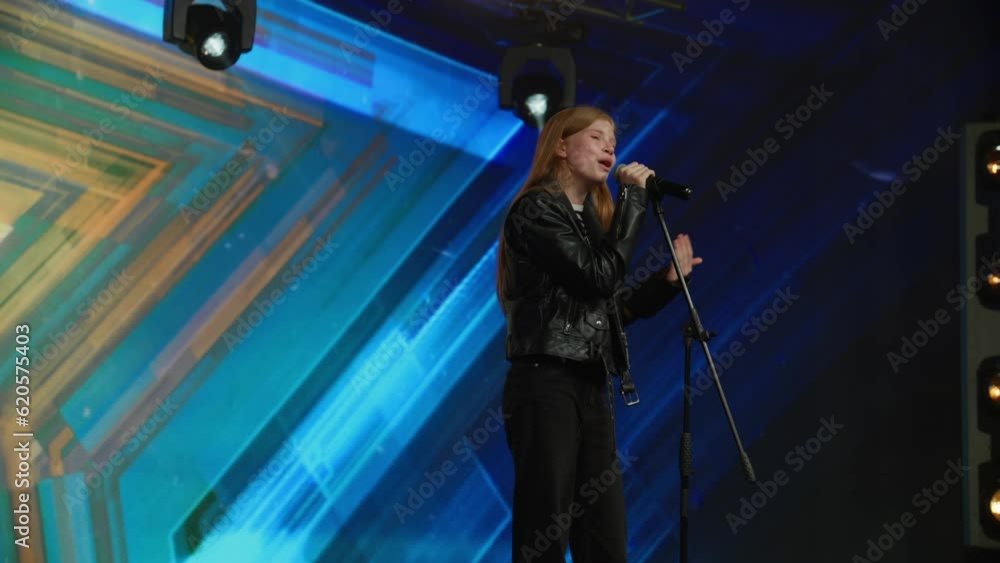 Young teenager girl singer performing on stage, contestant singing ...