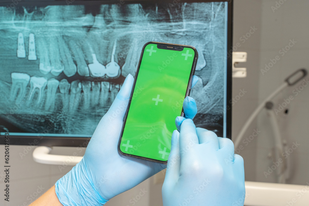 Closeup dentist hands sterile glove hold green screen cellphone at ...