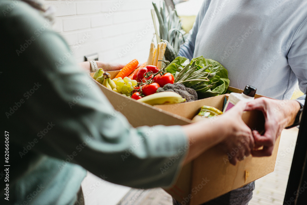 Food courier handing over food delivery at the door Stock Photo | Adobe ...