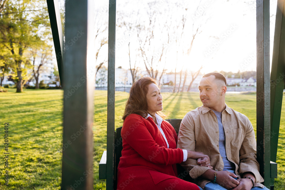 Conversation between parent and adult child on the park bench. Stock ...