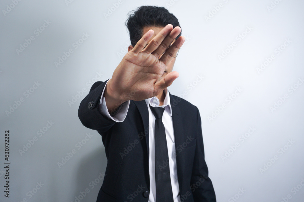 Handsome asian young man wearing suit seriously showing stop gesture ...