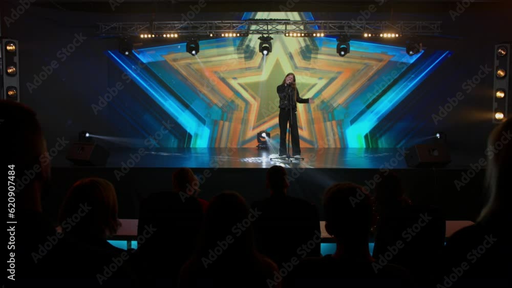 Young teenager girl singer performing on stage, contestant singing ...