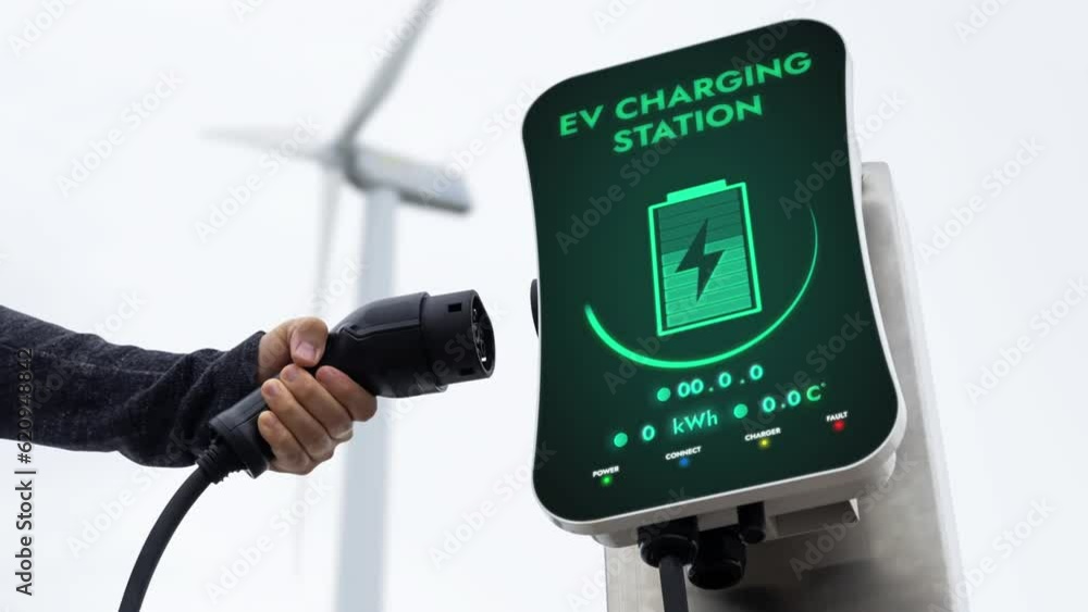 Hand pull EV charger from EV car charging station in nature and wind ...