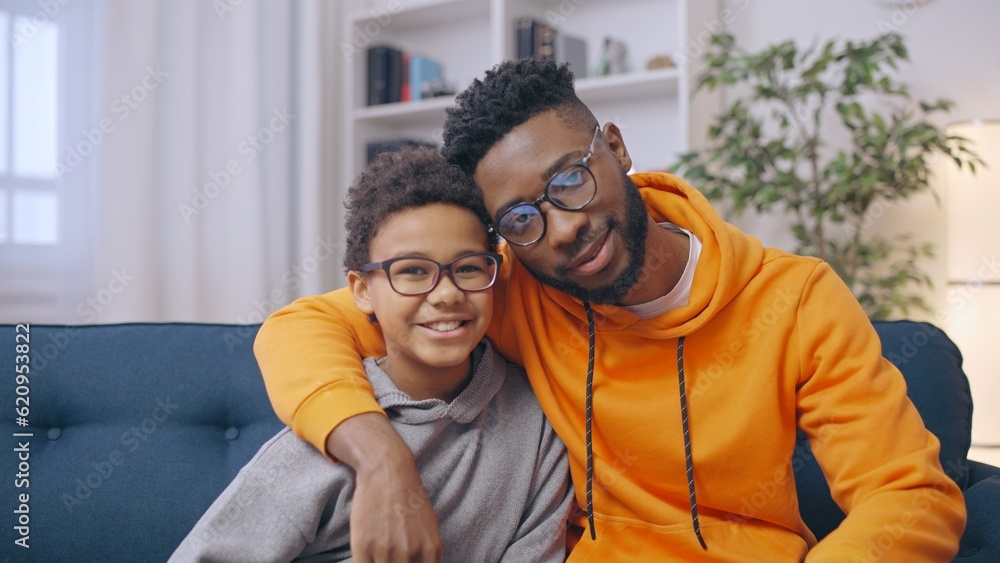 Portrait of African American brothers hugging on sofa at home, happy ...