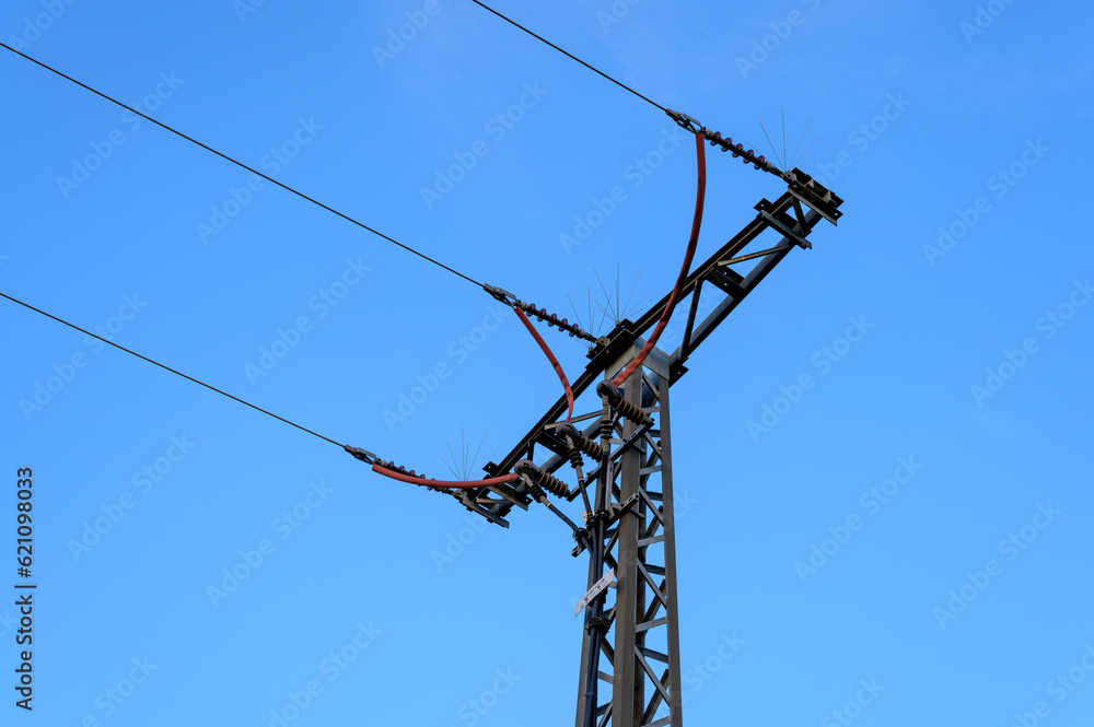 A three phase power line pylon terminates into a ground cable with anti ...
