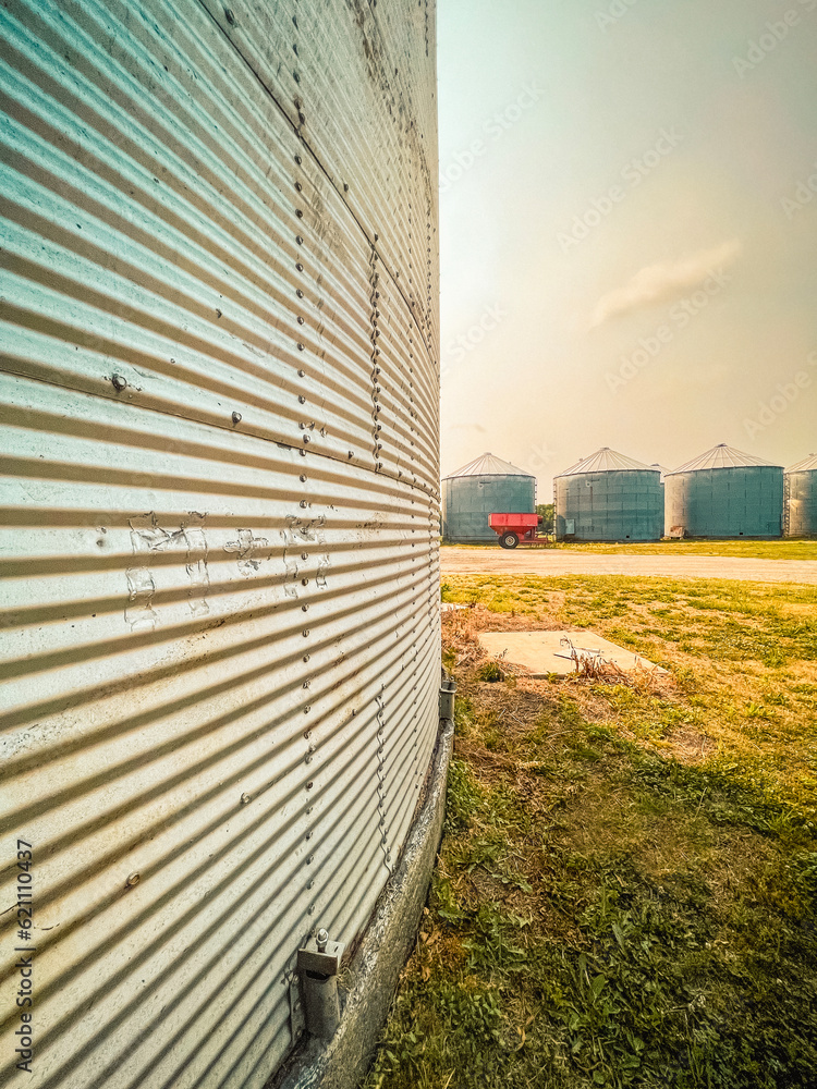 Side view of the corrugated round wall of a grain silo. In the distance ...
