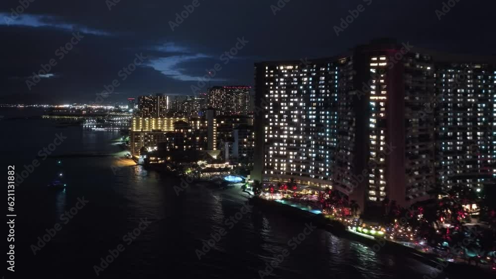 Drone flying along world famous hotels and resort at night on Waikiki ...