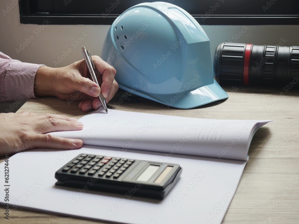 engineer design building and sign signature in printed drawing plan ...