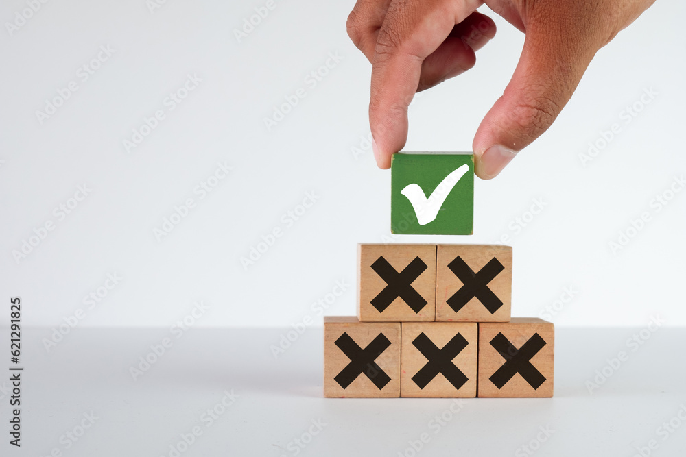 Hand picking Green Wooden cube with check mark(correct ) icon among ...