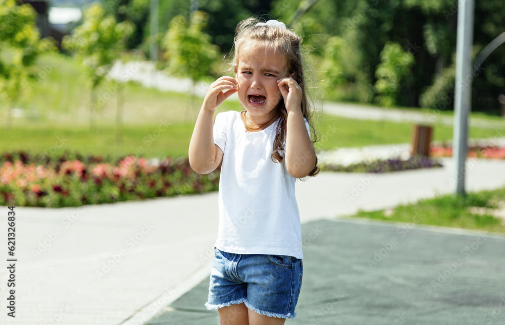 Cute caucasian baby, little girl crying on the playground in the park ...