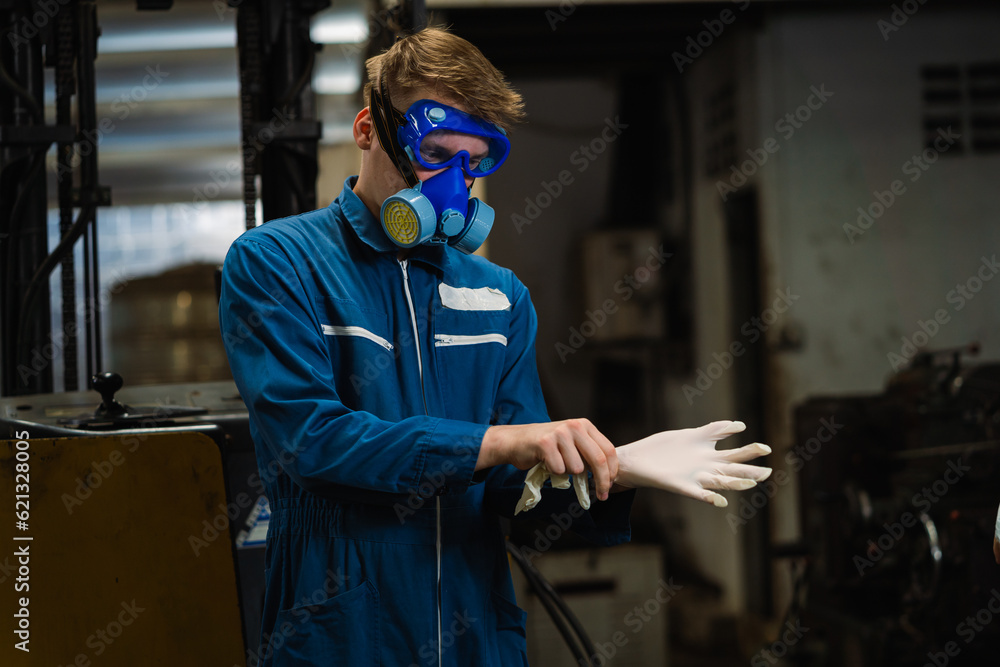 Professional male worker in protective suit and gas mask handling ...
