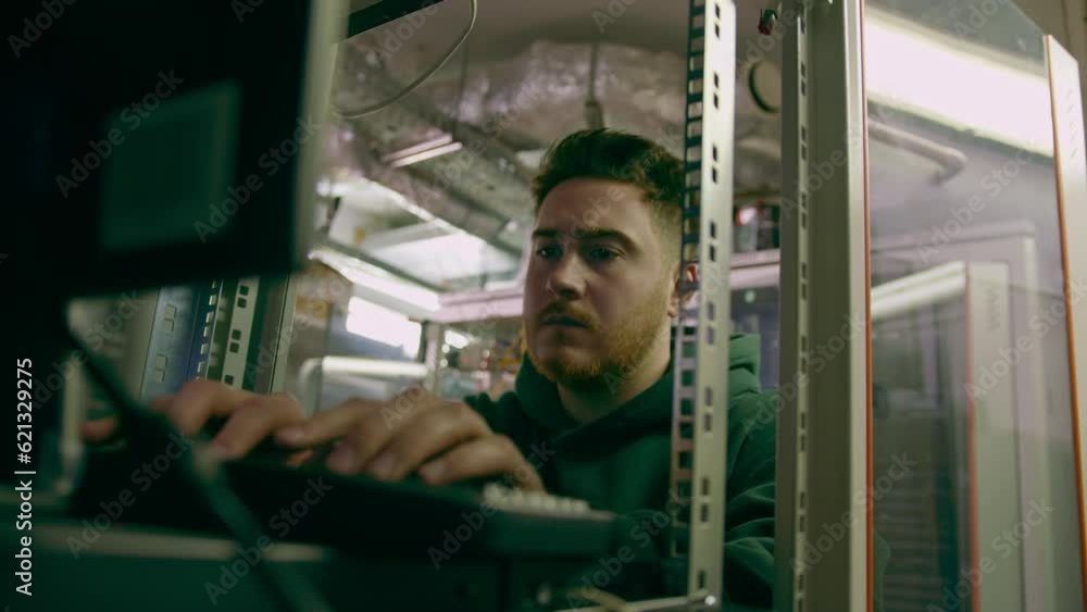 focused hacker in data center hacking software system vulnerable cyber security server room ...