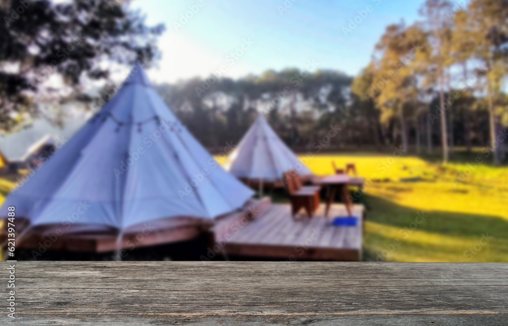 Wooden table top on blur tent camping travel tent and grass field.Fresh ...