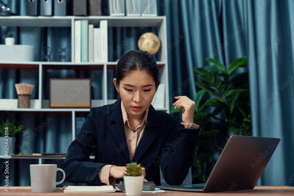 Young asian businesswoman is diligently working and taking notes in her ...
