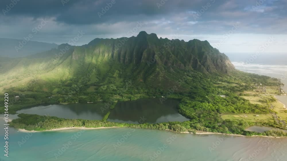 Drone flying over green jungle mountain peaks revealing tropical beach ...