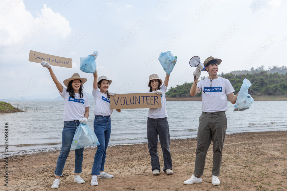 Group of volunteers holding rubbish bags and sign to campaign to save ...