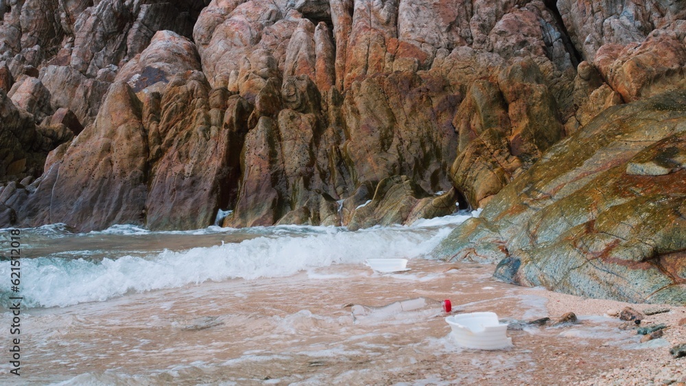 Debris-infested beach with majestic cliffs. Example of how people are ...