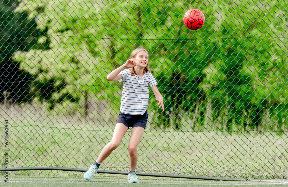 Pretty child girl catching football ball defending goal. Cute female ...