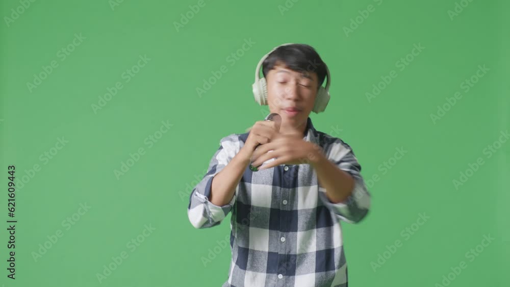 Young Asian Teen Boy Holding A Microphone And Rapping On The The Green ...