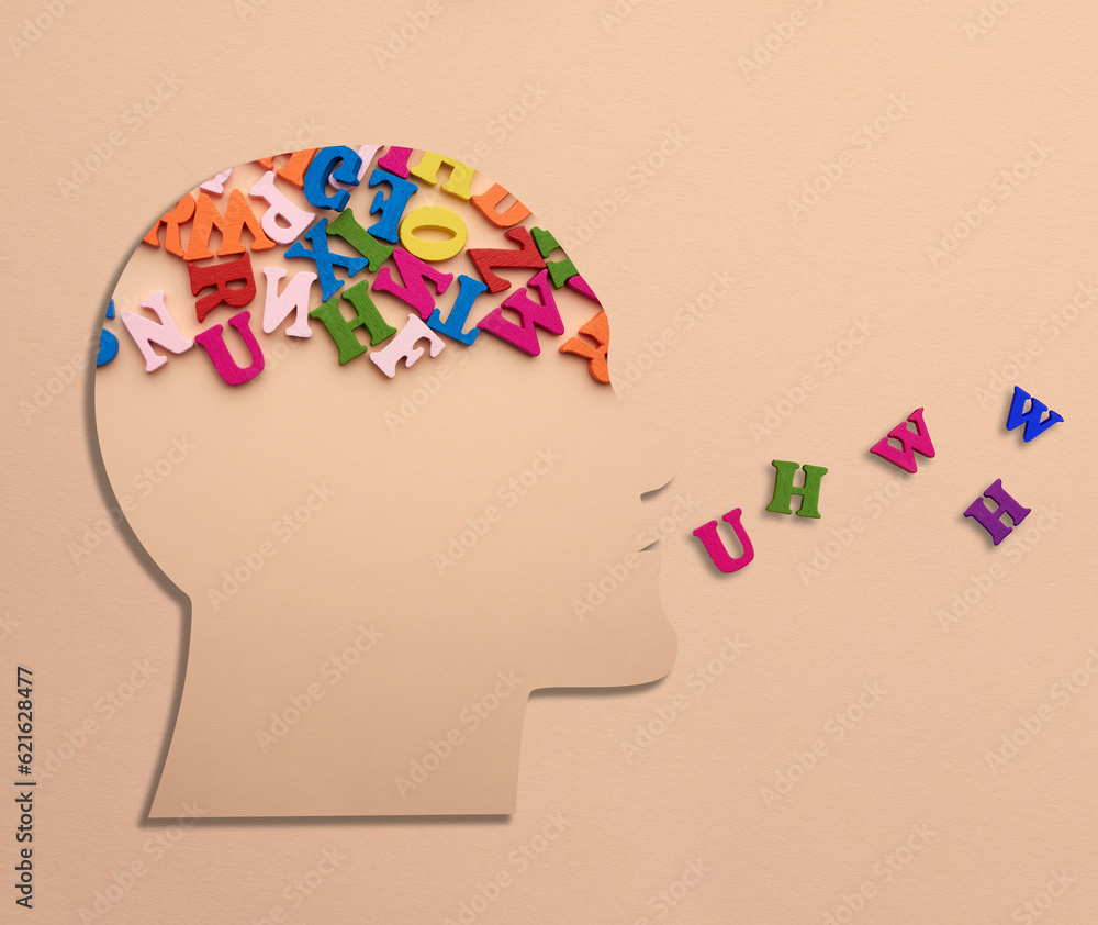 Silhouette of a human head with letters in the brain on a beige ...