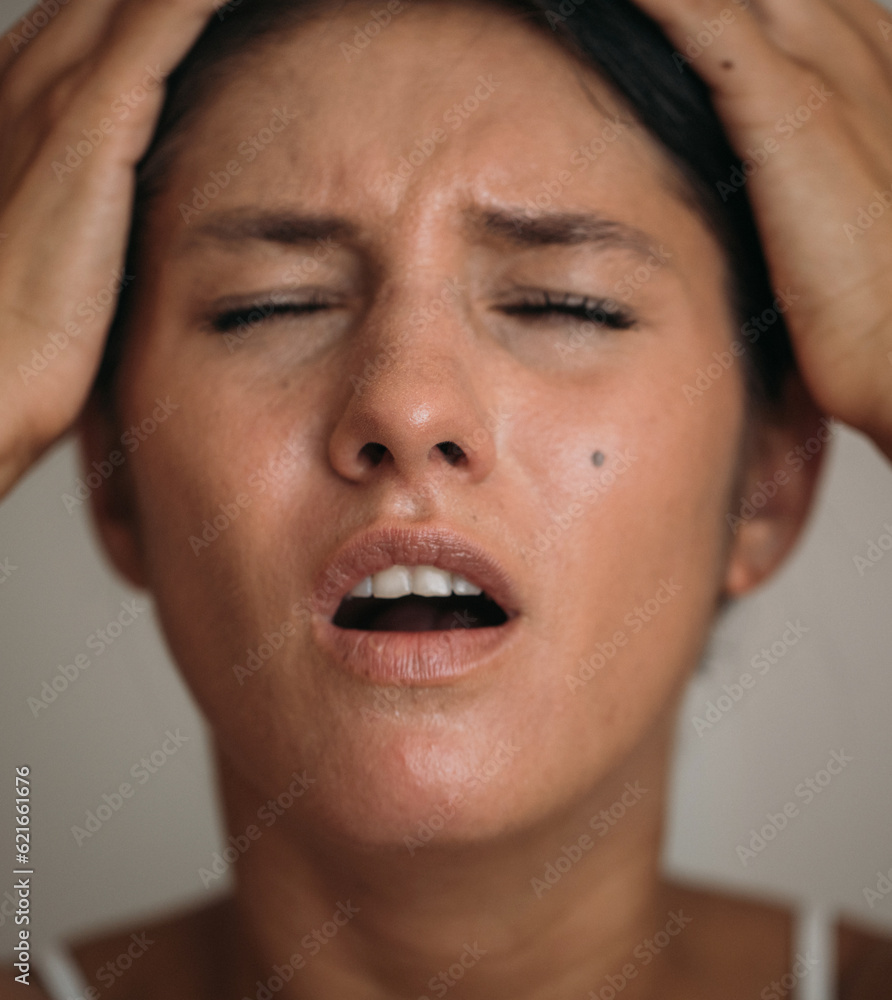 Sad tired young woman touching her forehead, with headache, migraine or ...