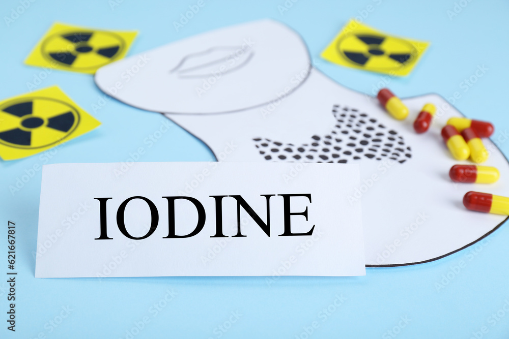 Paper note with word Iodine, radiation signs, cutout of thyroid gland ...