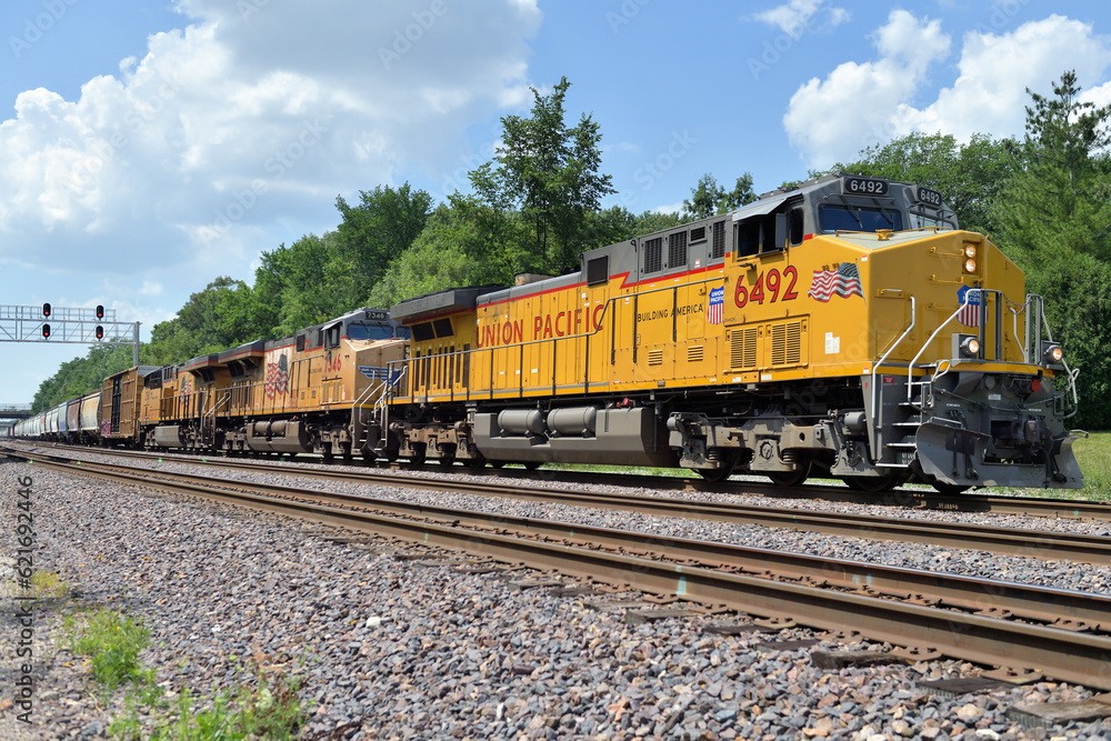 Multiple locomotives lead a long Union Pacific freight train under a ...