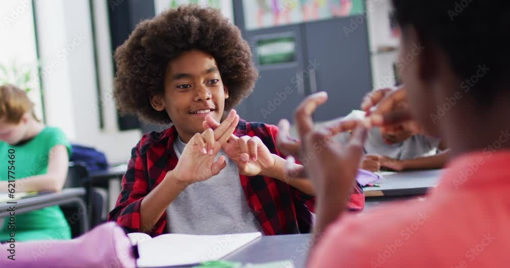 Vidéo Stock Diverse female teacher and happy schoolchildren at desks ...