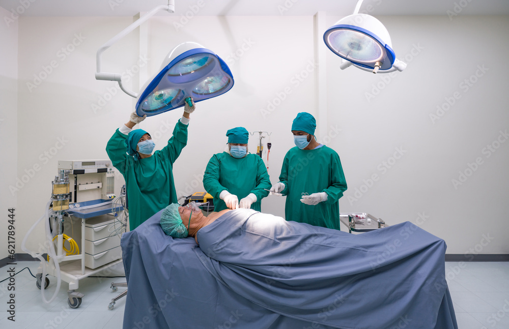 Nurse adjusting surgical lights. Group of surgeons and nurse in ...