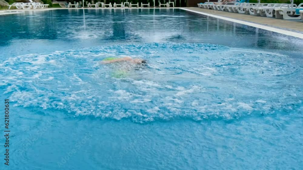 Happy child jumping into the summer outdoor pool. Little girl has fun ...