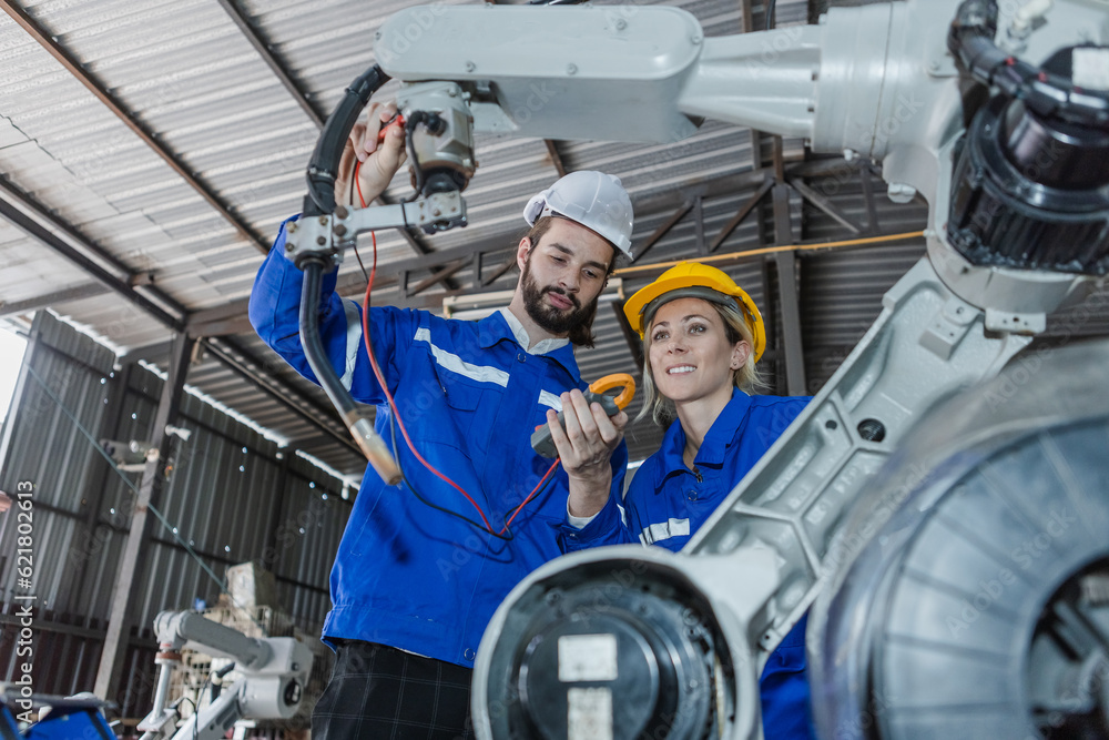 Team technician engineer checking automation robotics arm at industrial ...