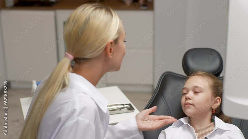 Tracking shot of professional pediatric dentist bonding with adorable ...
