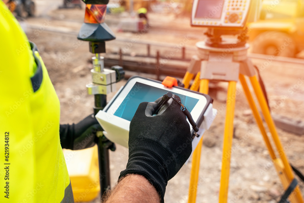 Site engineer surveyor using rugged tablet controller computer to ...