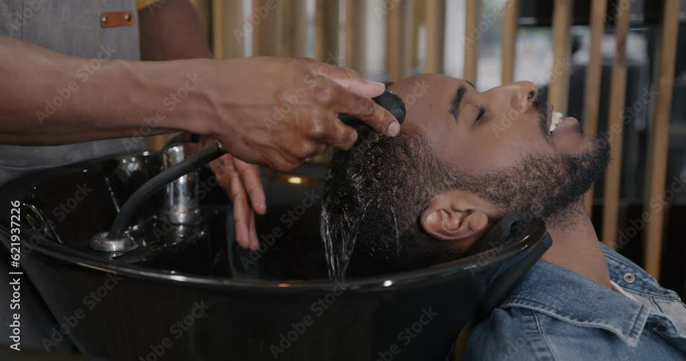 Satisfied client enjoying hygiene procedure in barbershop while barber ...