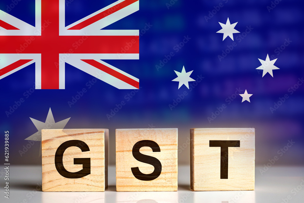 GST displayed on wooden letter blocks with Australia flag background ...