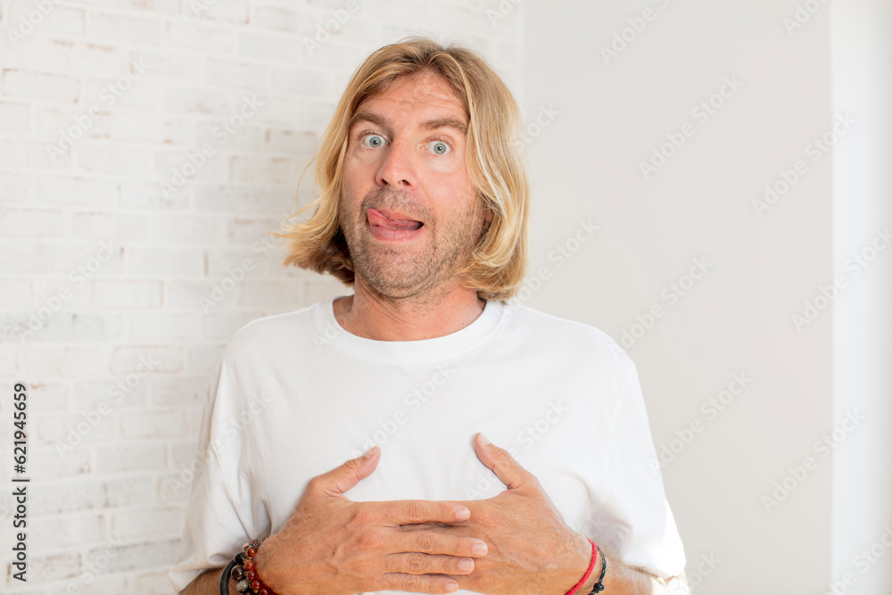 young blond adult man with a goofy, crazy and surprised expression ...