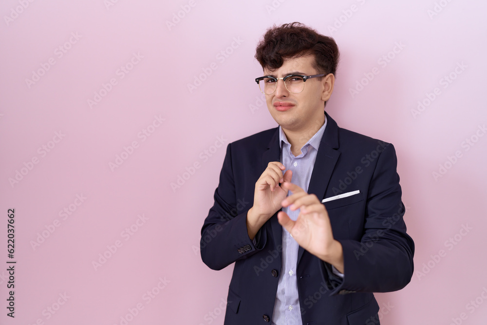Young non binary man with beard wearing suit and tie disgusted ...