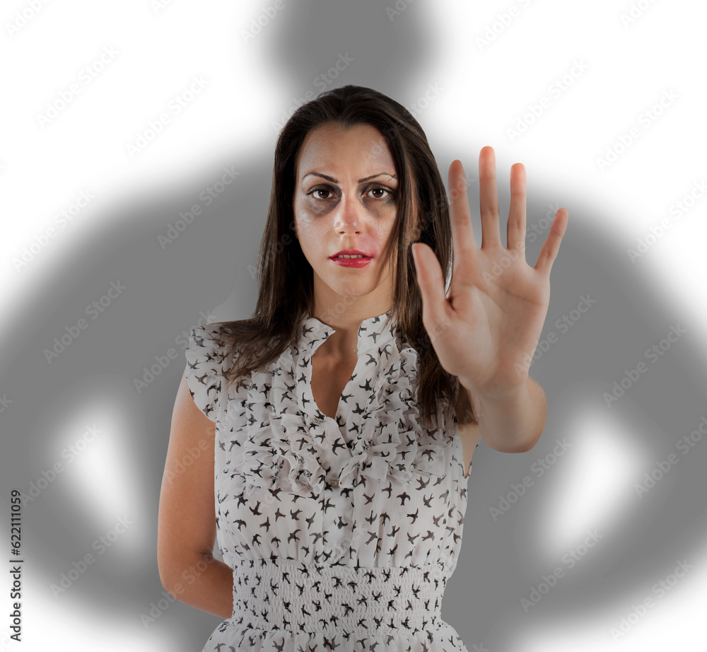 Scared woman with bruises and scratches with shadow of a man behind her ...