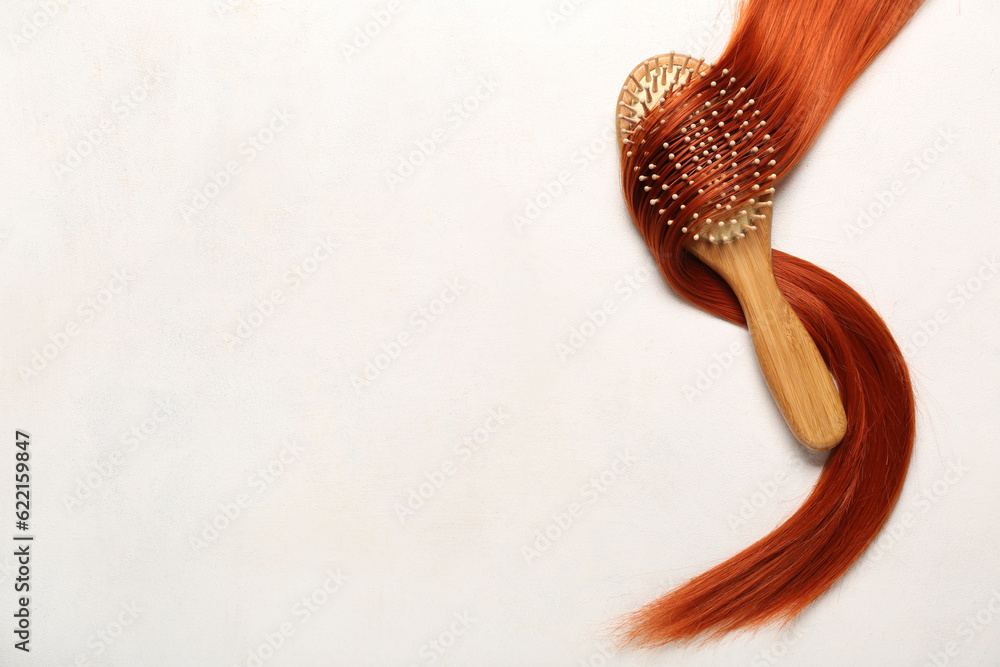 Ginger hair strand with brush on light background Stock Photo | Adobe Stock